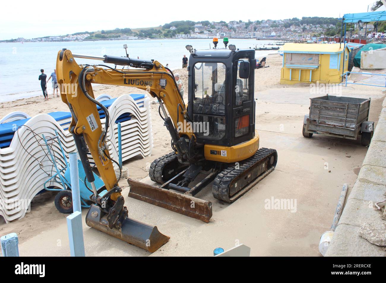 A photo of a small digger on a beach in England Stock Photo - Alamy