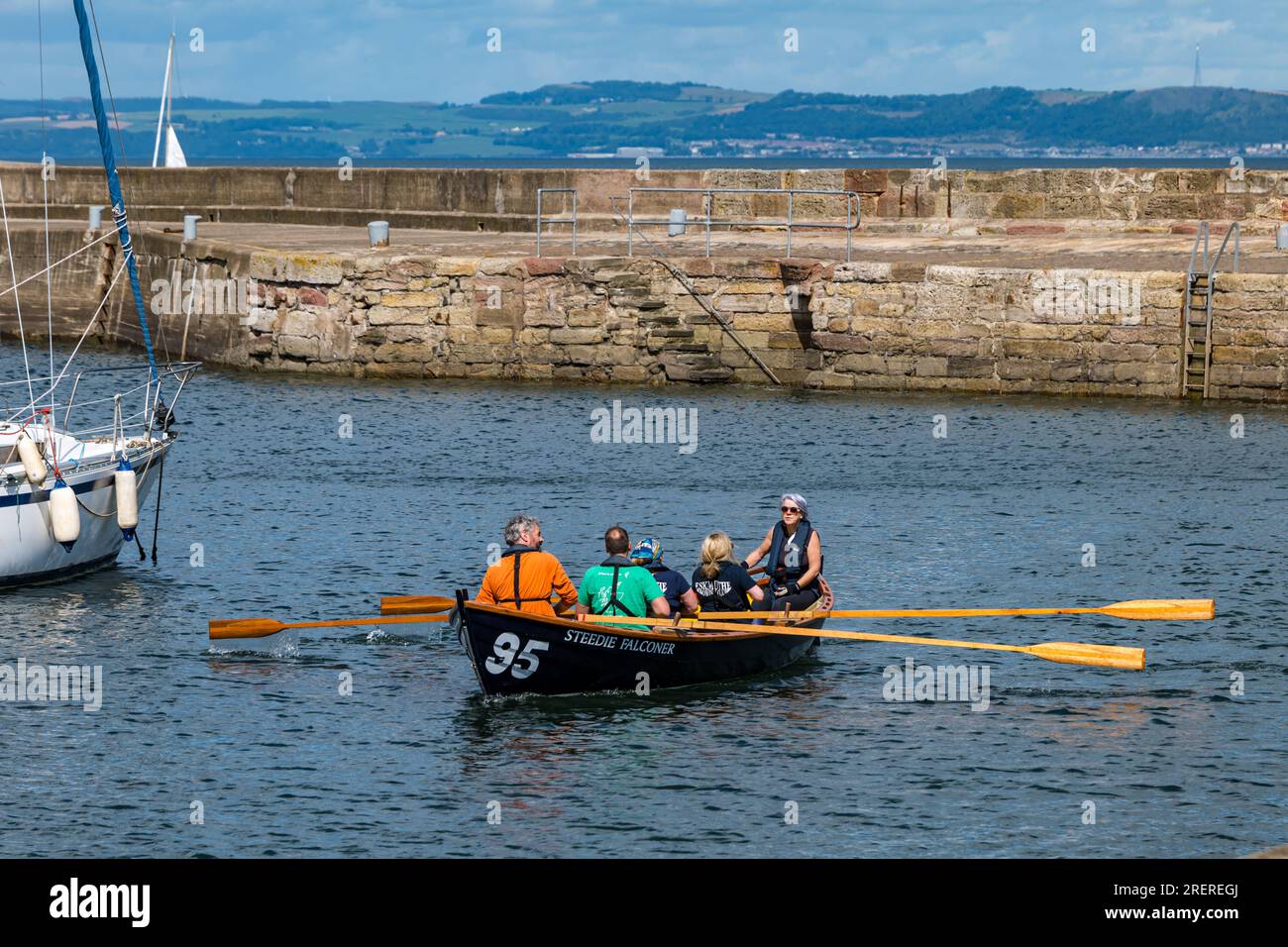 People in St Ayles rowing skiff, Fisherrow Harbour, Musselburgh, East ...