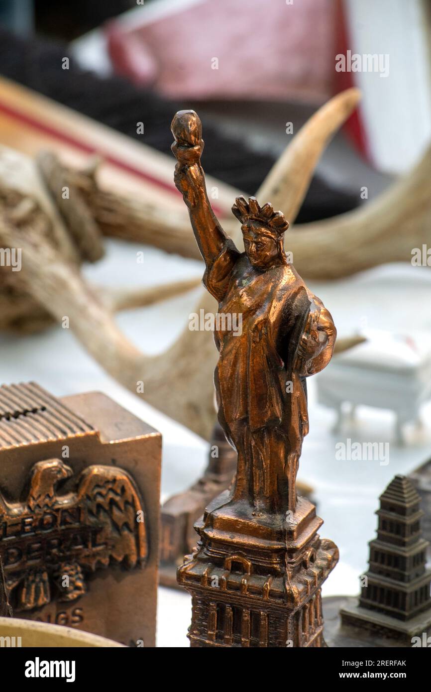 A small statue of liberty statue is for sale an an outdoor yard sale ...