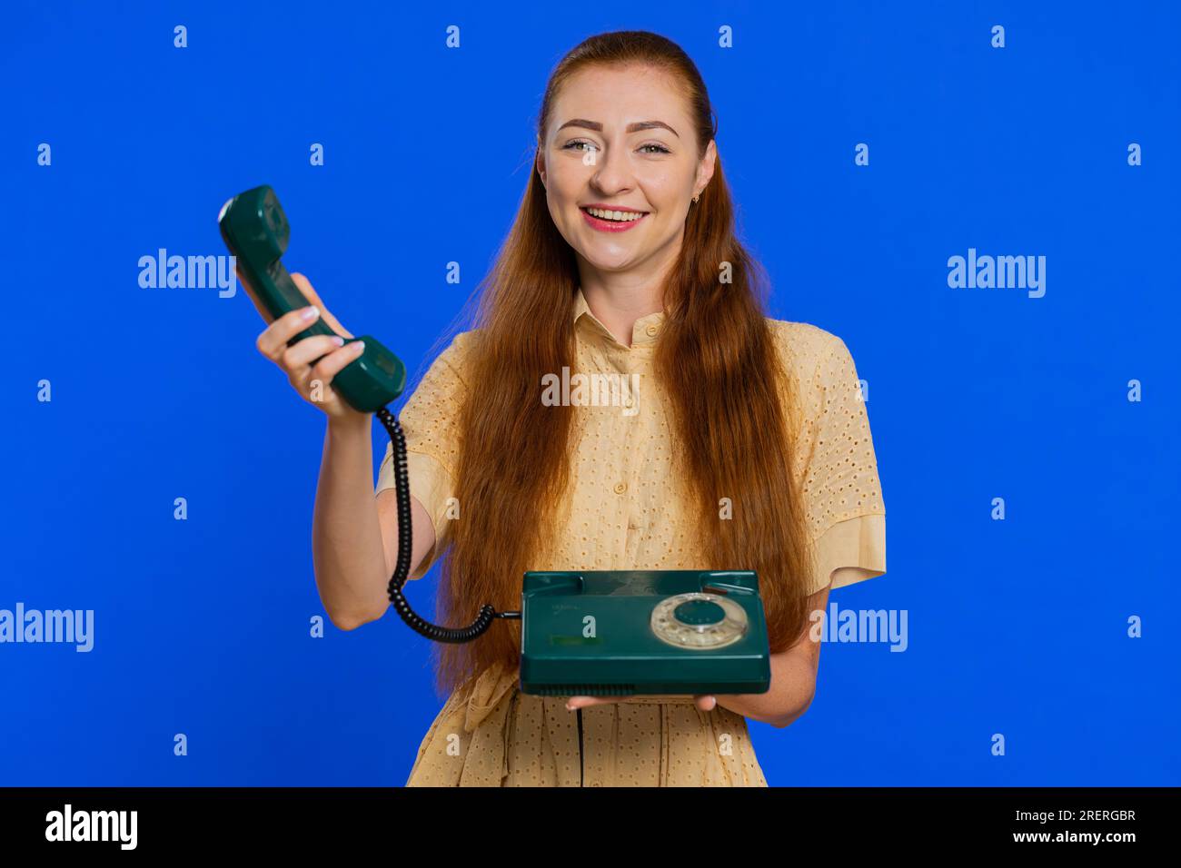 Hey you, call me back. Adult woman talking on wired vintage telephone ...