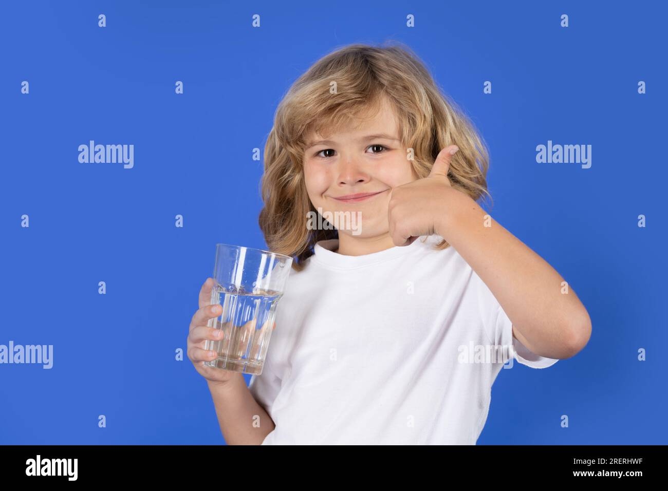 Kid drinking water, isolated on studio background. Cute blonde child ...