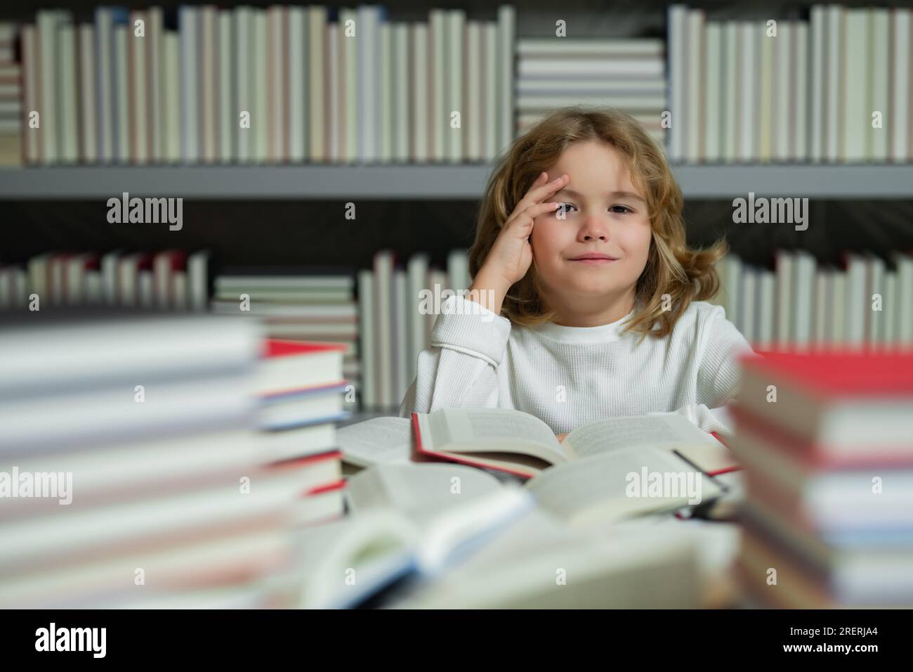 Thinking school kid. Child reading book in a book store or school ...