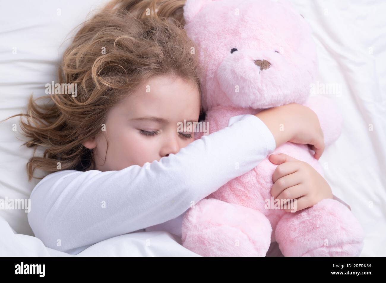Good morning sleep. Little boy sleeping in bed with a toy teddy bear ...