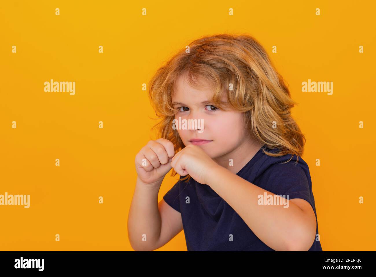 Angry child with fist gesture fight, hit on yellow studio isolated ...
