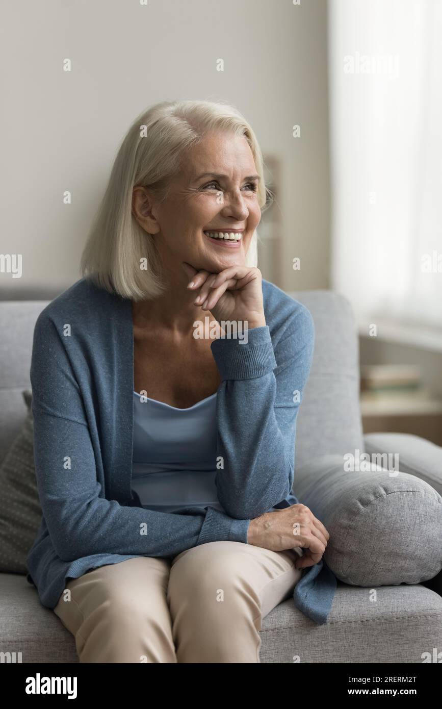 Happy pretty old mature woman relaxing on home couch Stock Photo - Alamy