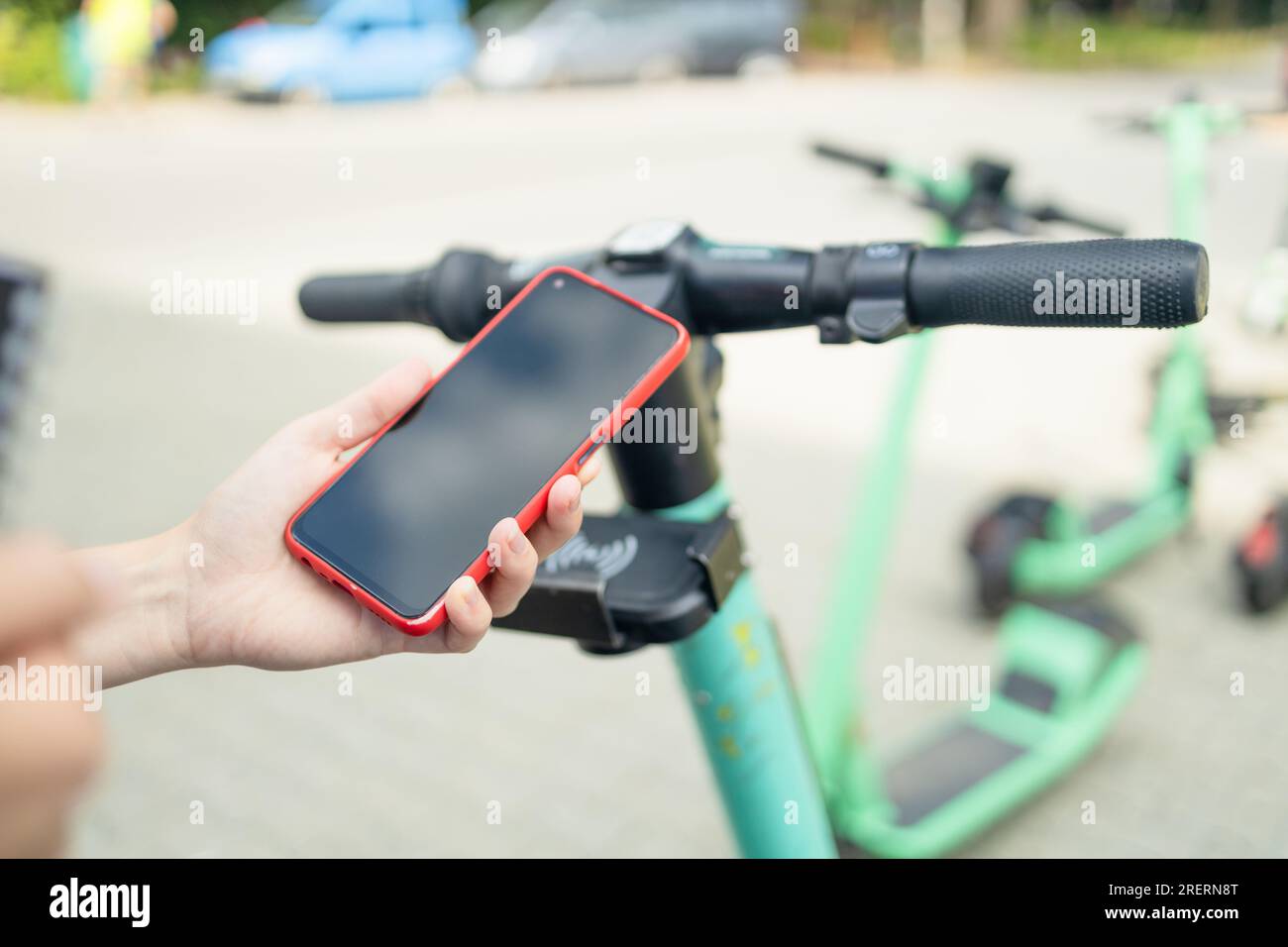 Woman rents electric scooter using mobile phone app at the street ...