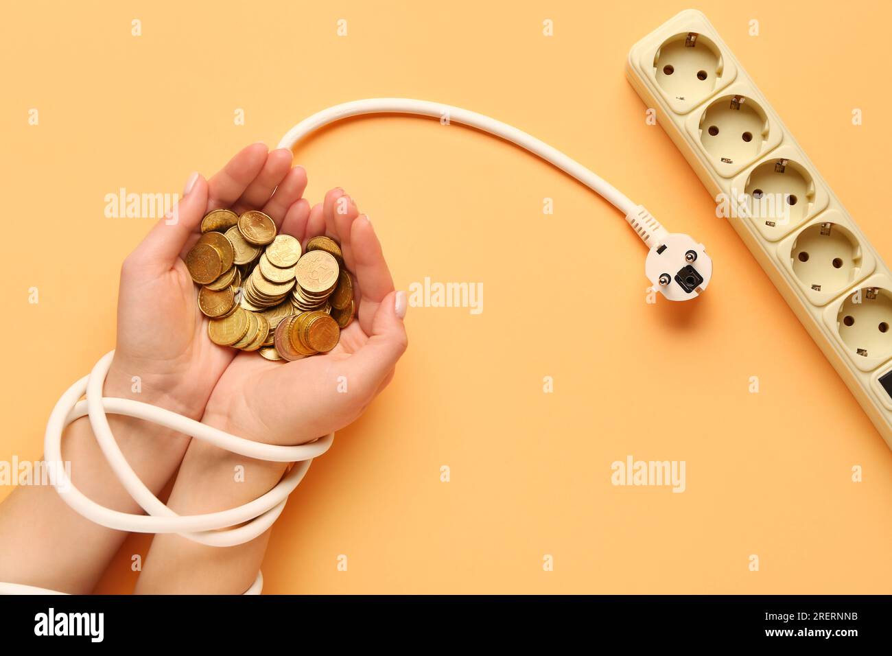 Woman with coins, plug and power socket on orange background ...