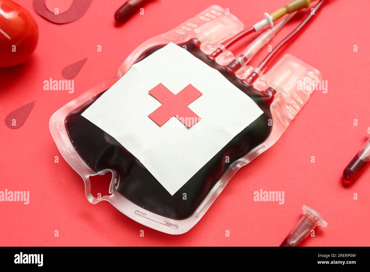 Blood pack with tubes and paper drops on red background, closeup. World ...