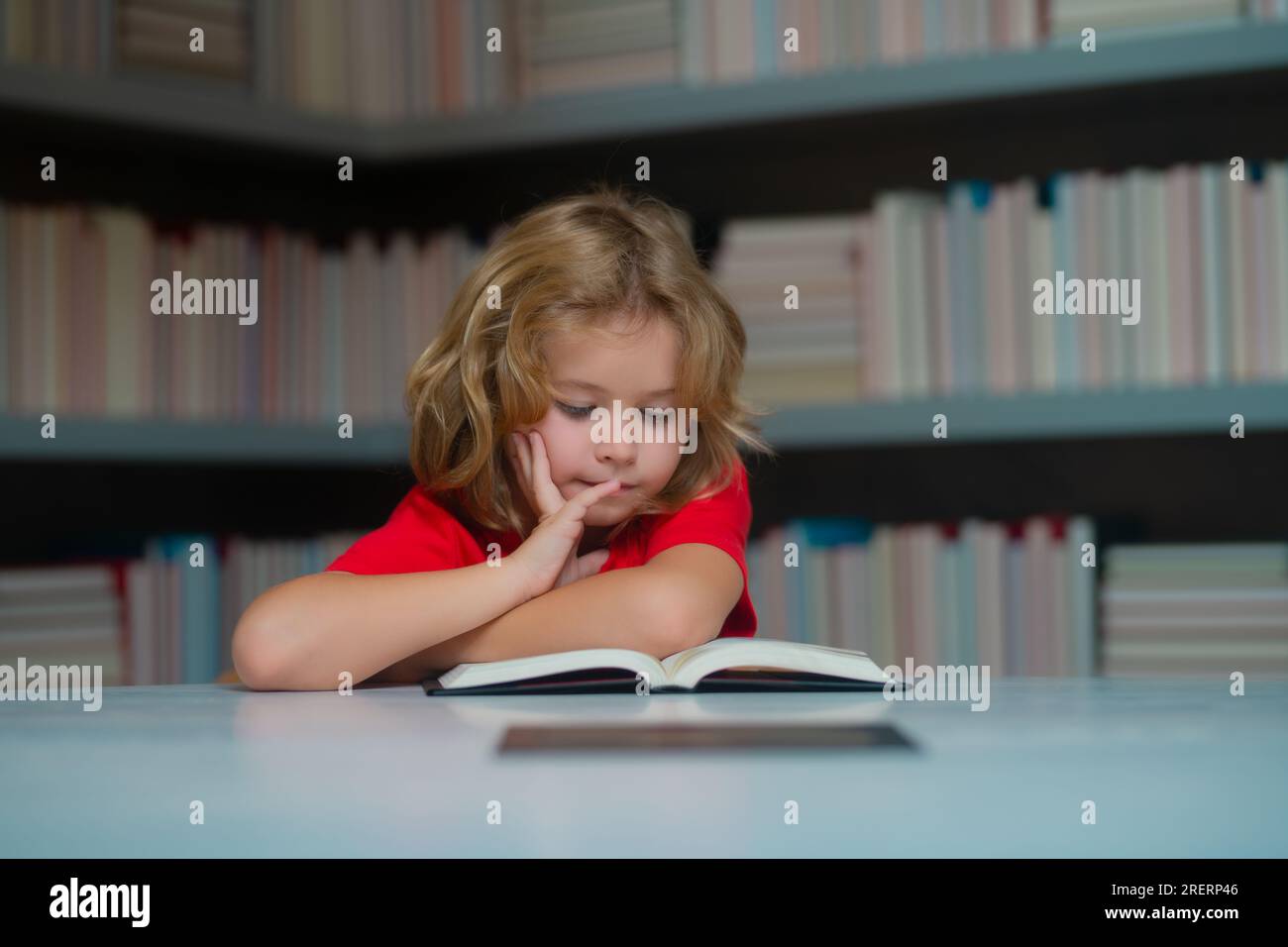 Thinking school kid. Schoolboy reading book in library. Kids ...