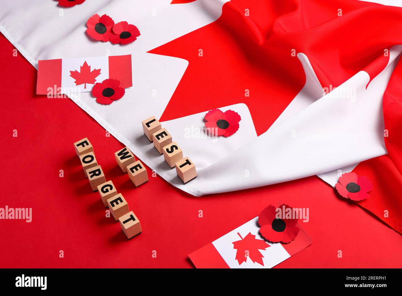 Poppy flowers with flags of Canada and text LEST WE FORGET on red ...