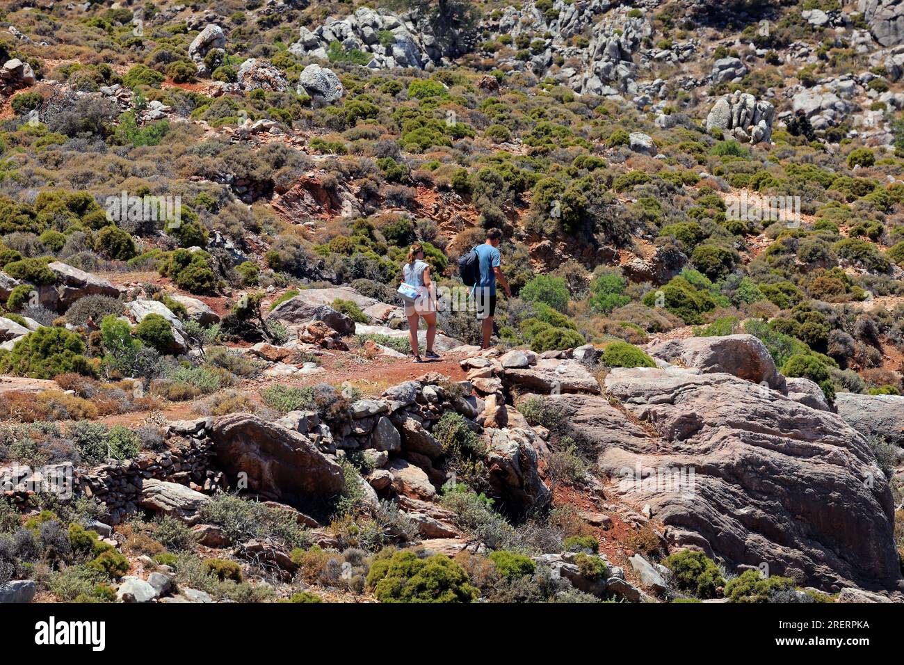 Young couple on the path from Livadia to Lethra beach along the rocky ...