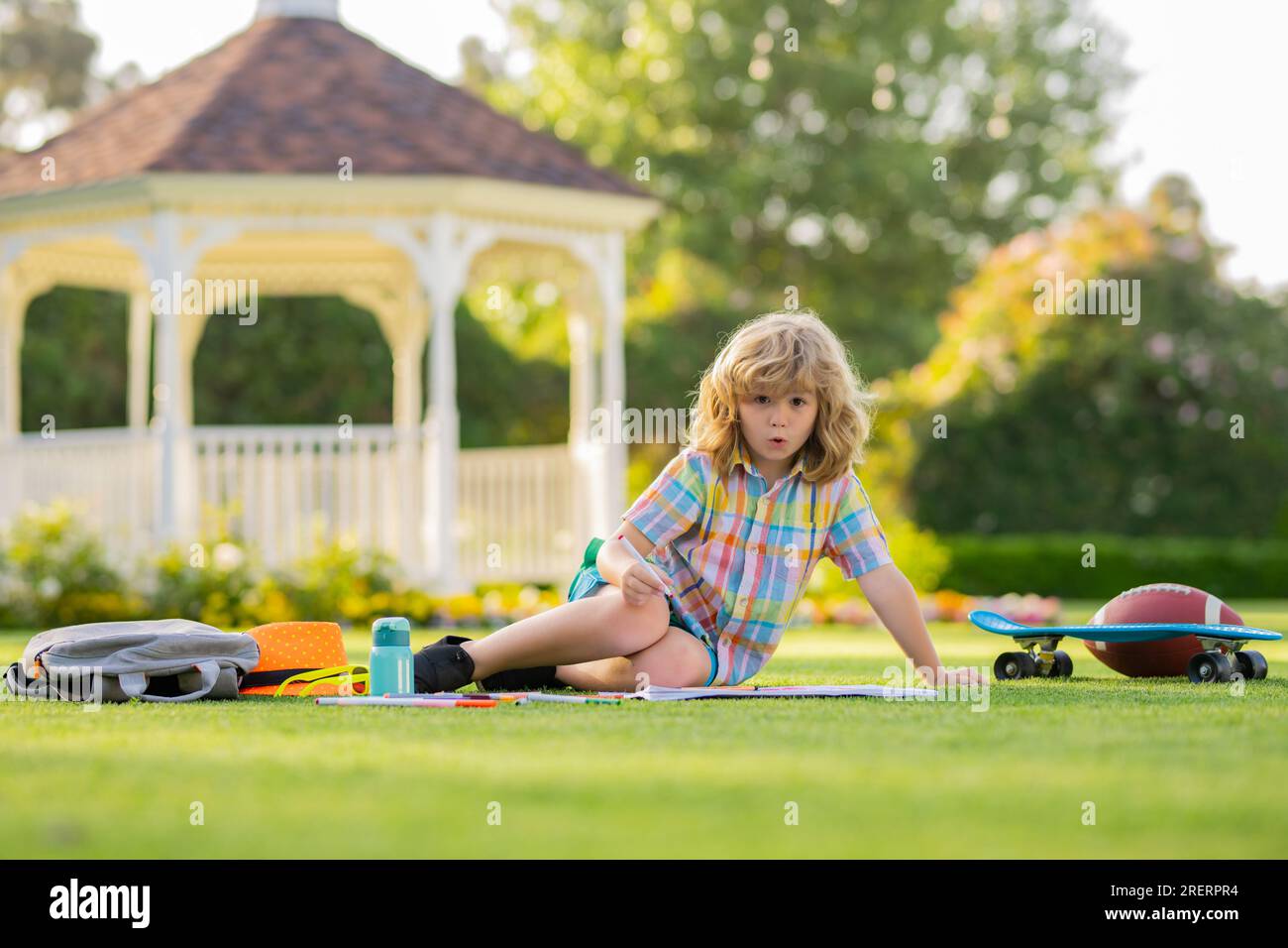 Summer leisure with children. School kid drawing in summer park ...