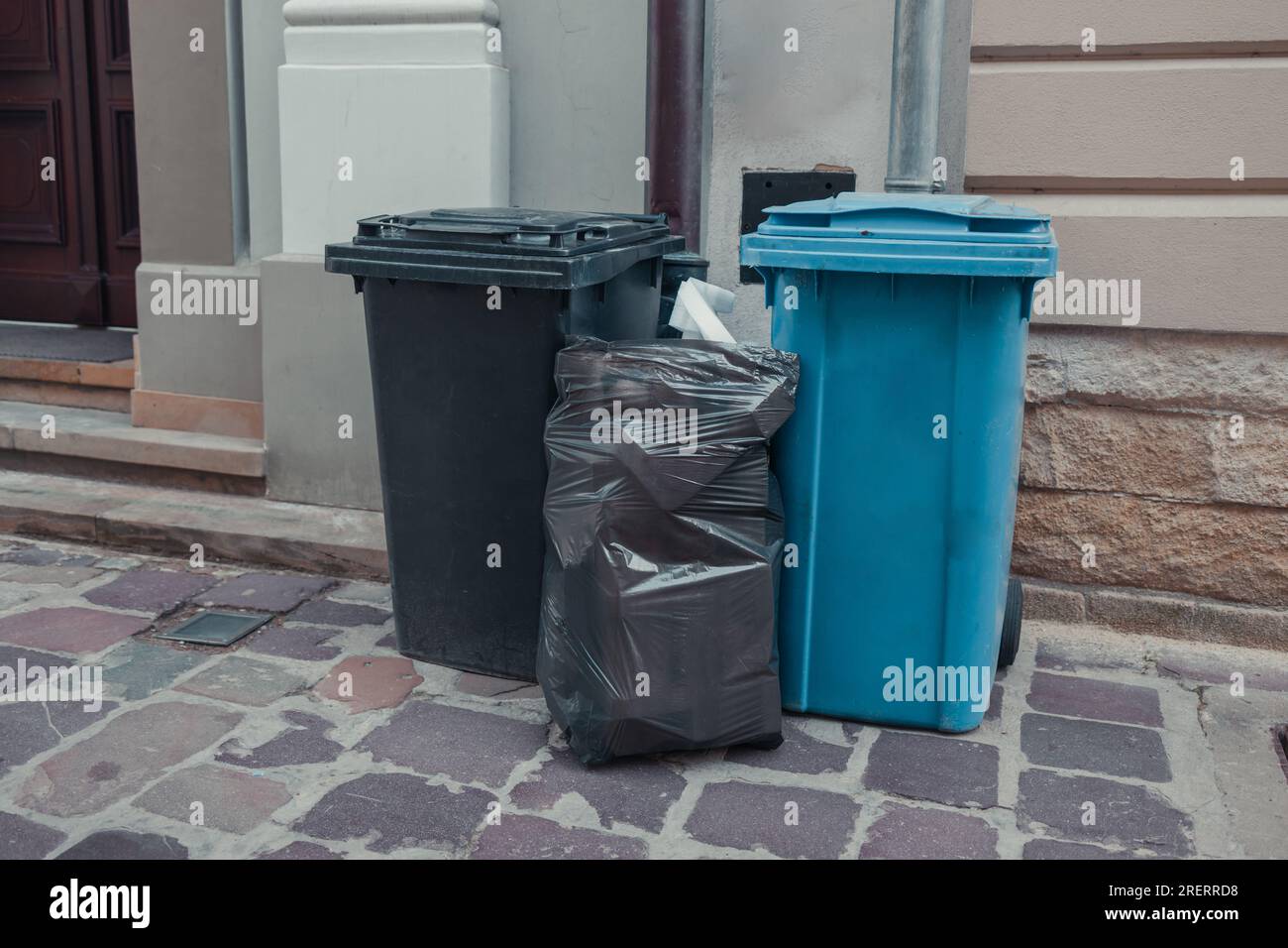 Rows of garbage cans of different colors in an alley in the city center ...