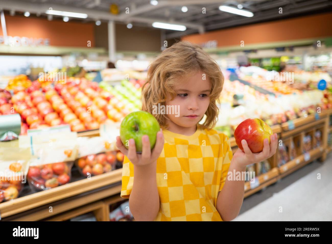 Child hold apple fruits at grocery store. Little child choosing food in ...