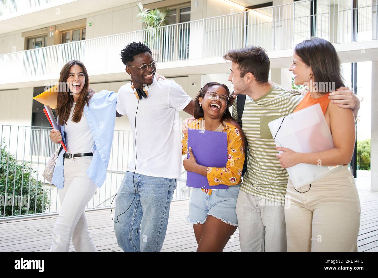 Group of university students hugging and walking outdoors the college ...