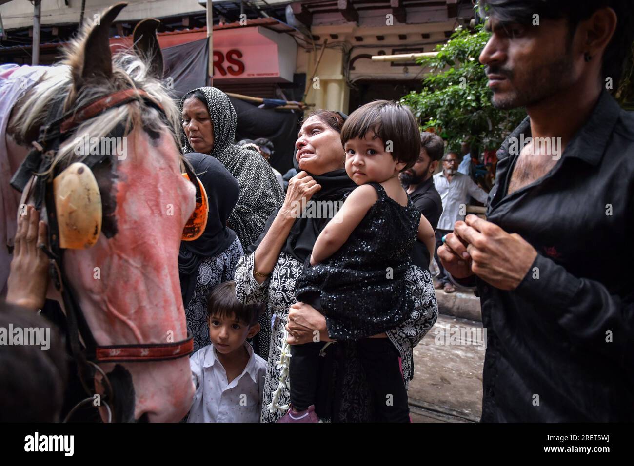 A woman cries in front of a horse that is decorated to reenact the ...