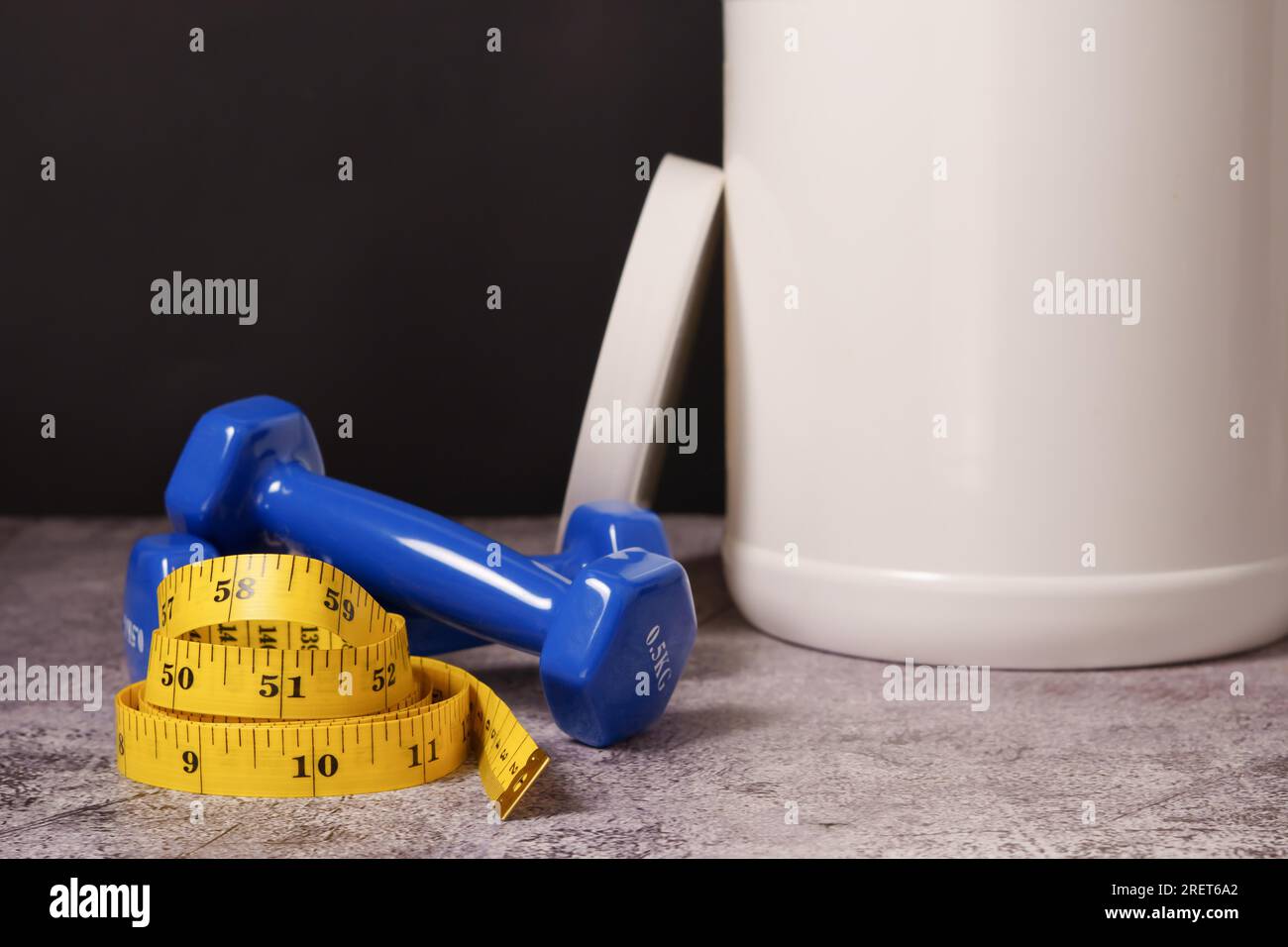 Whey protein powder, shaker, measuring tape and dumbbells on black ...