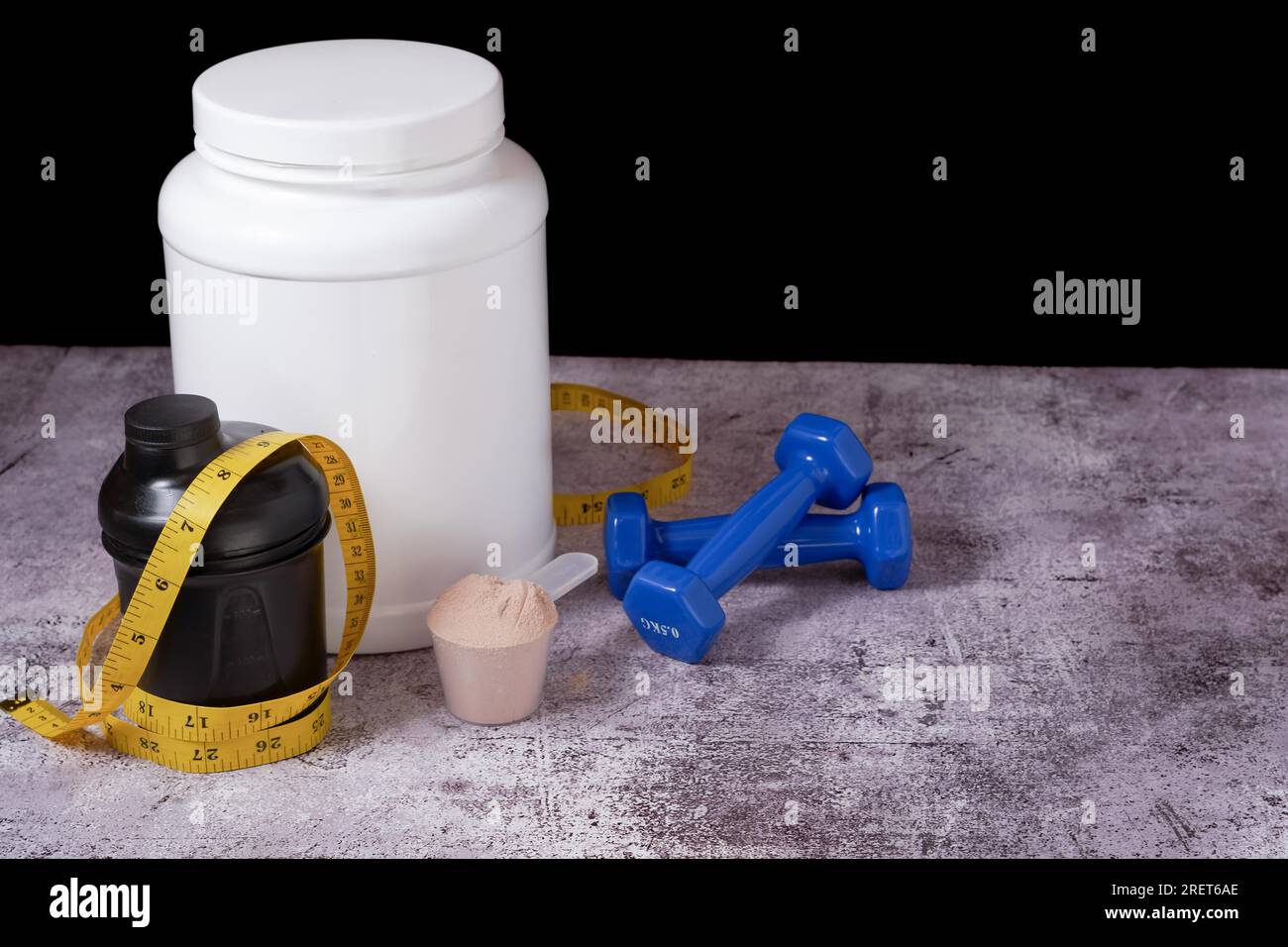 Whey protein powder, shaker, measuring tape and dumbbells on black ...