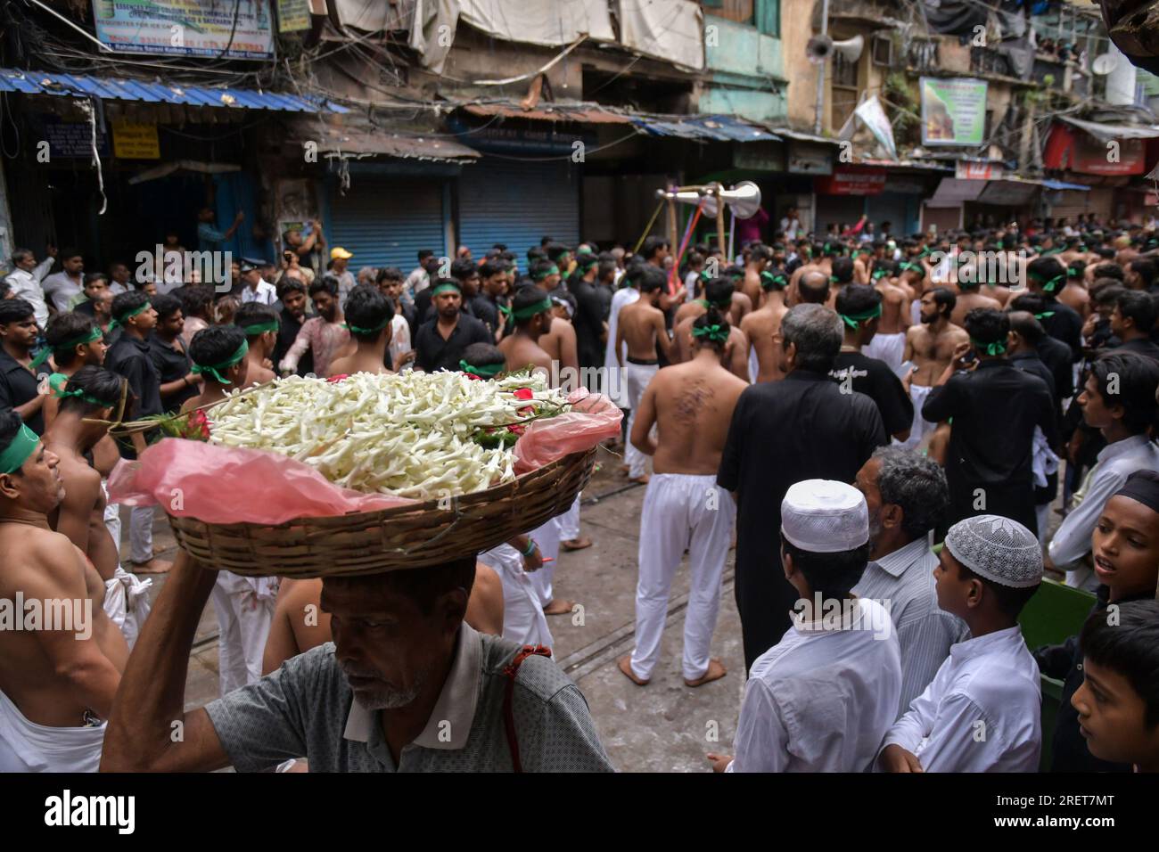 A flower vendor passes through a crowded lane while the Shia Muslims ...