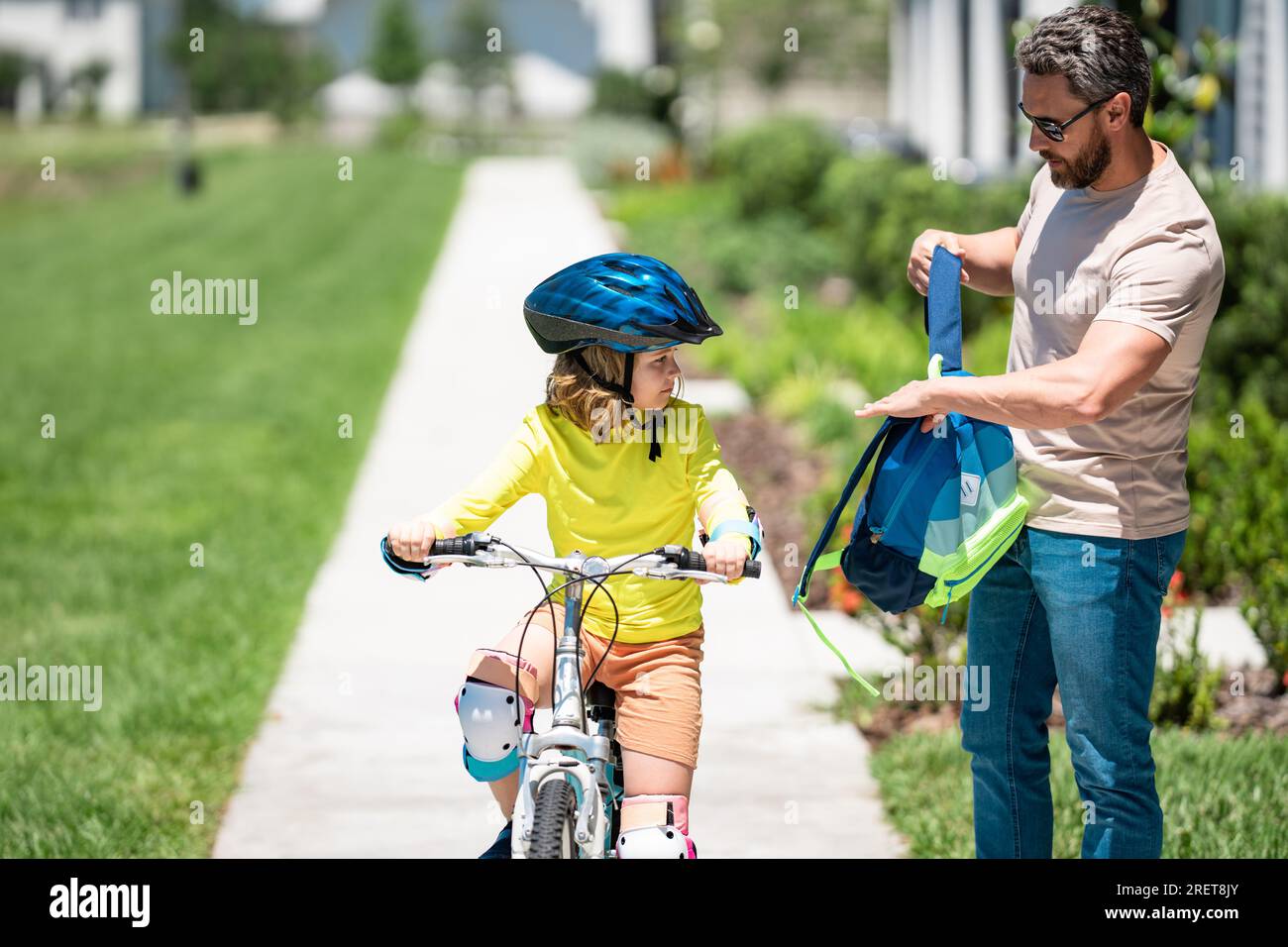 Father and son riding bike on a park. Child in safety helmet with ...