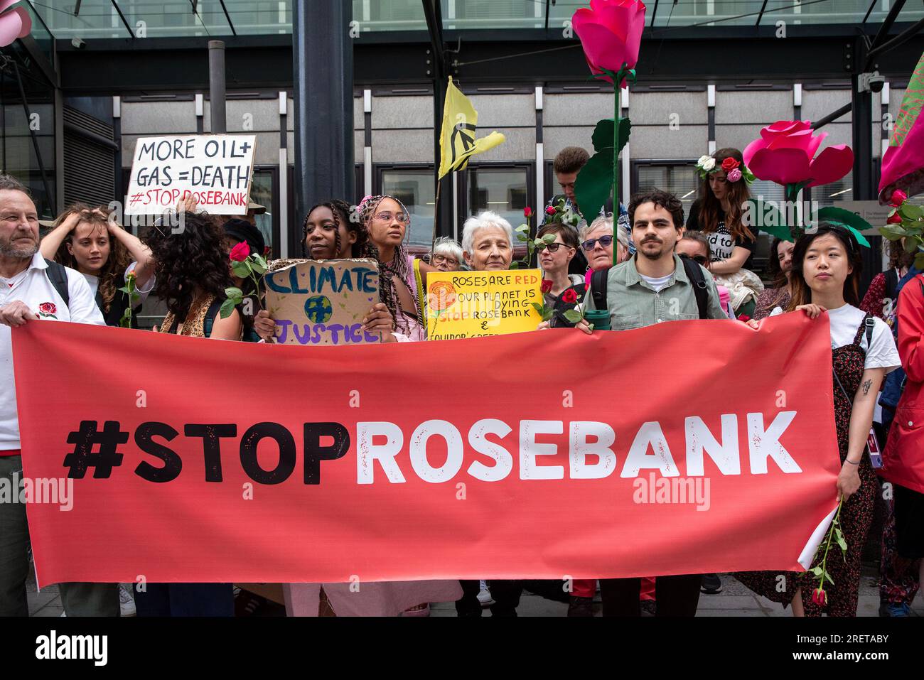 Protesters hold placards, a banner and roses outside the Westminster ...