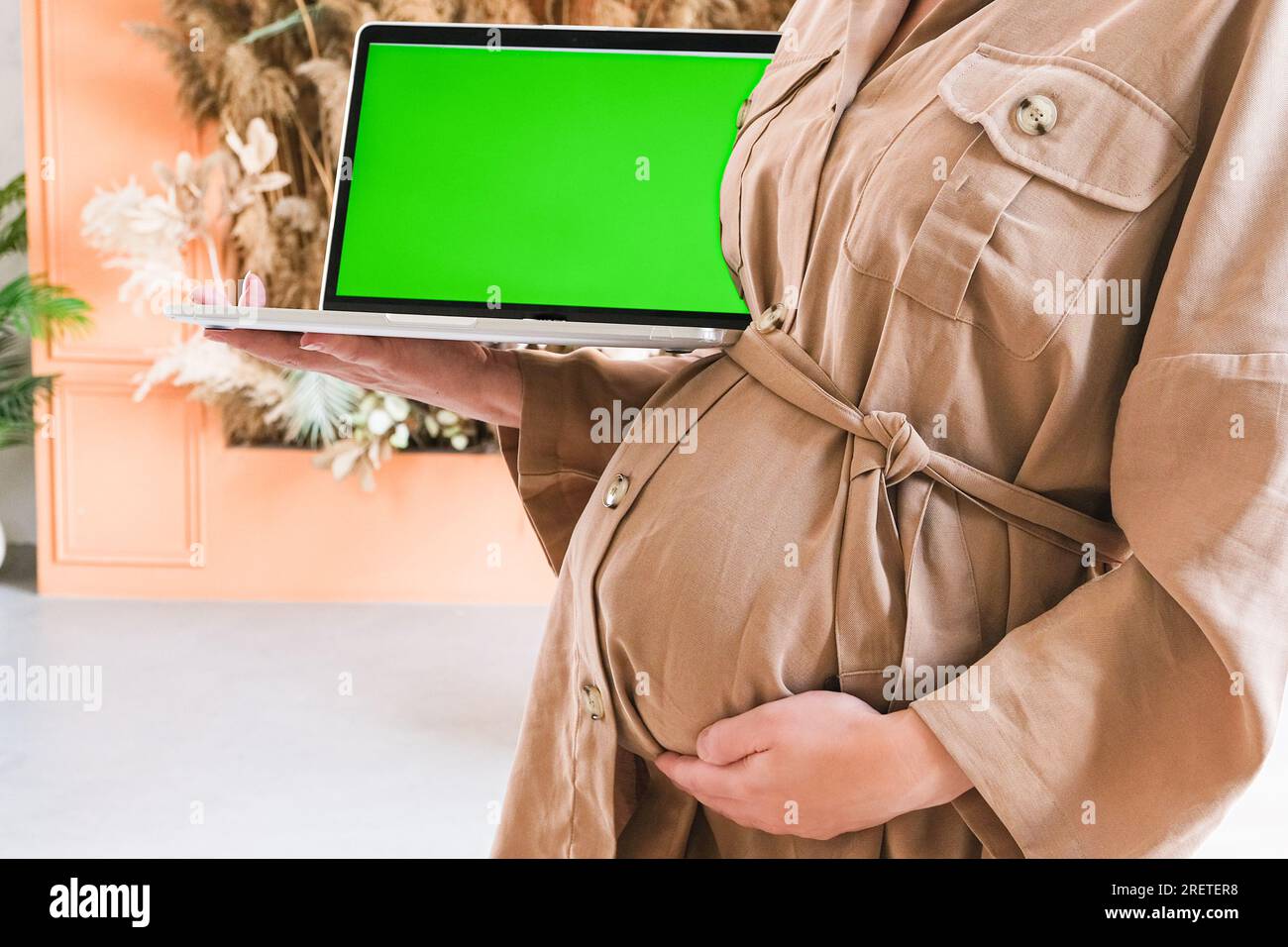A laptop computer with a green screen image on which a pregnant girl ...