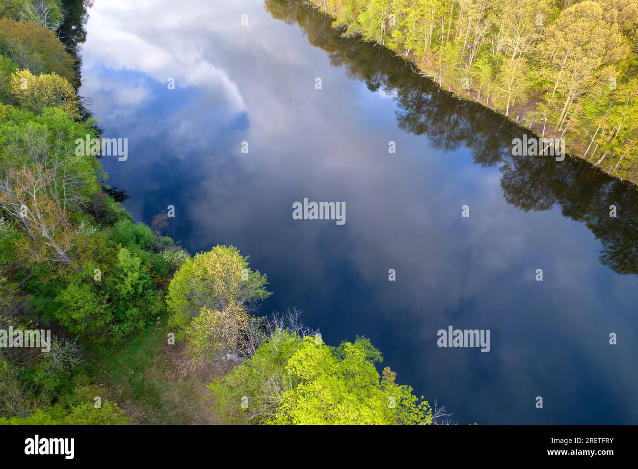 Trees with green leaves and the sky are reflected in an aerial view at ...