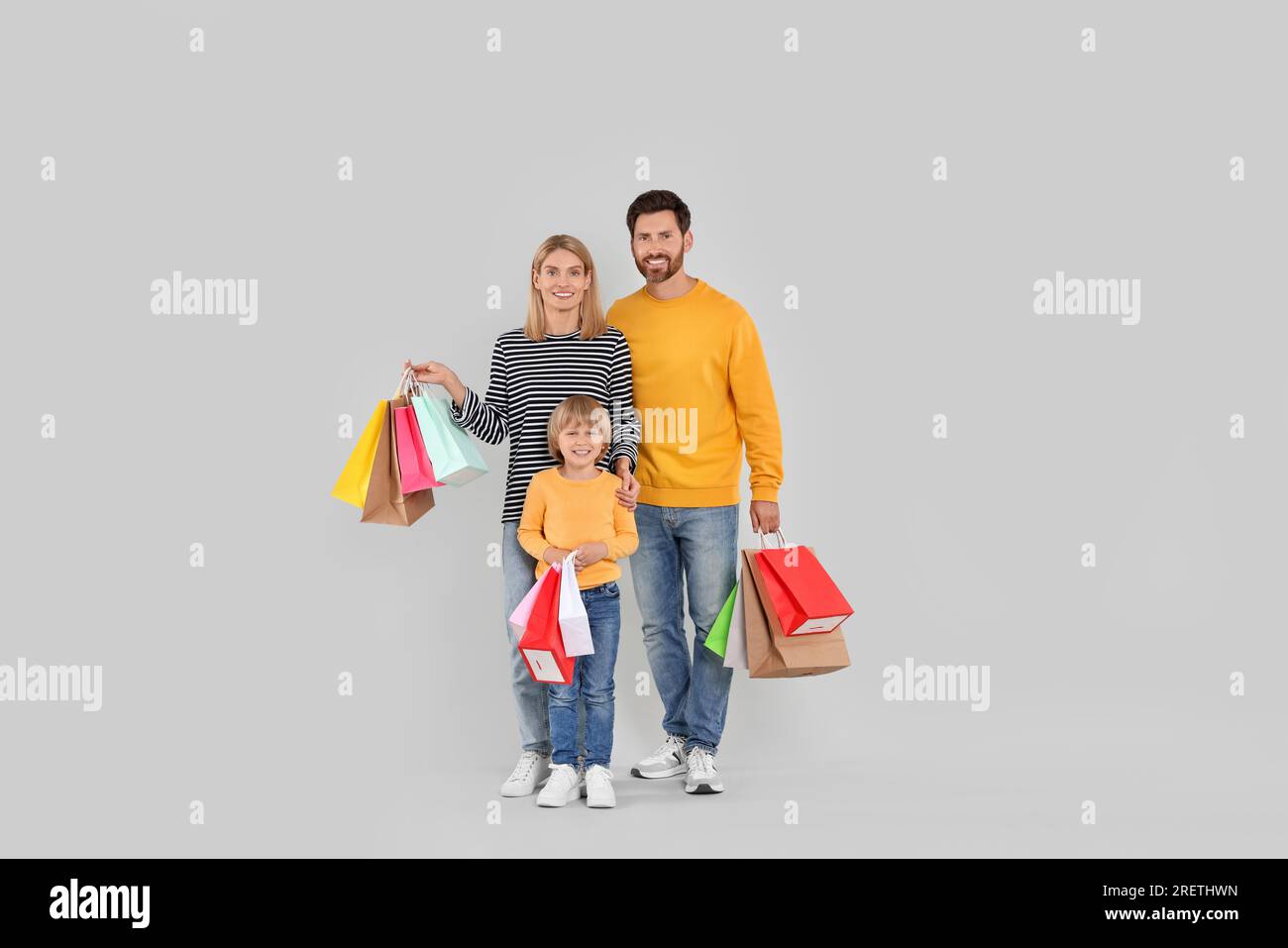 Family shopping. Happy parents and son with many colorful bags on light ...