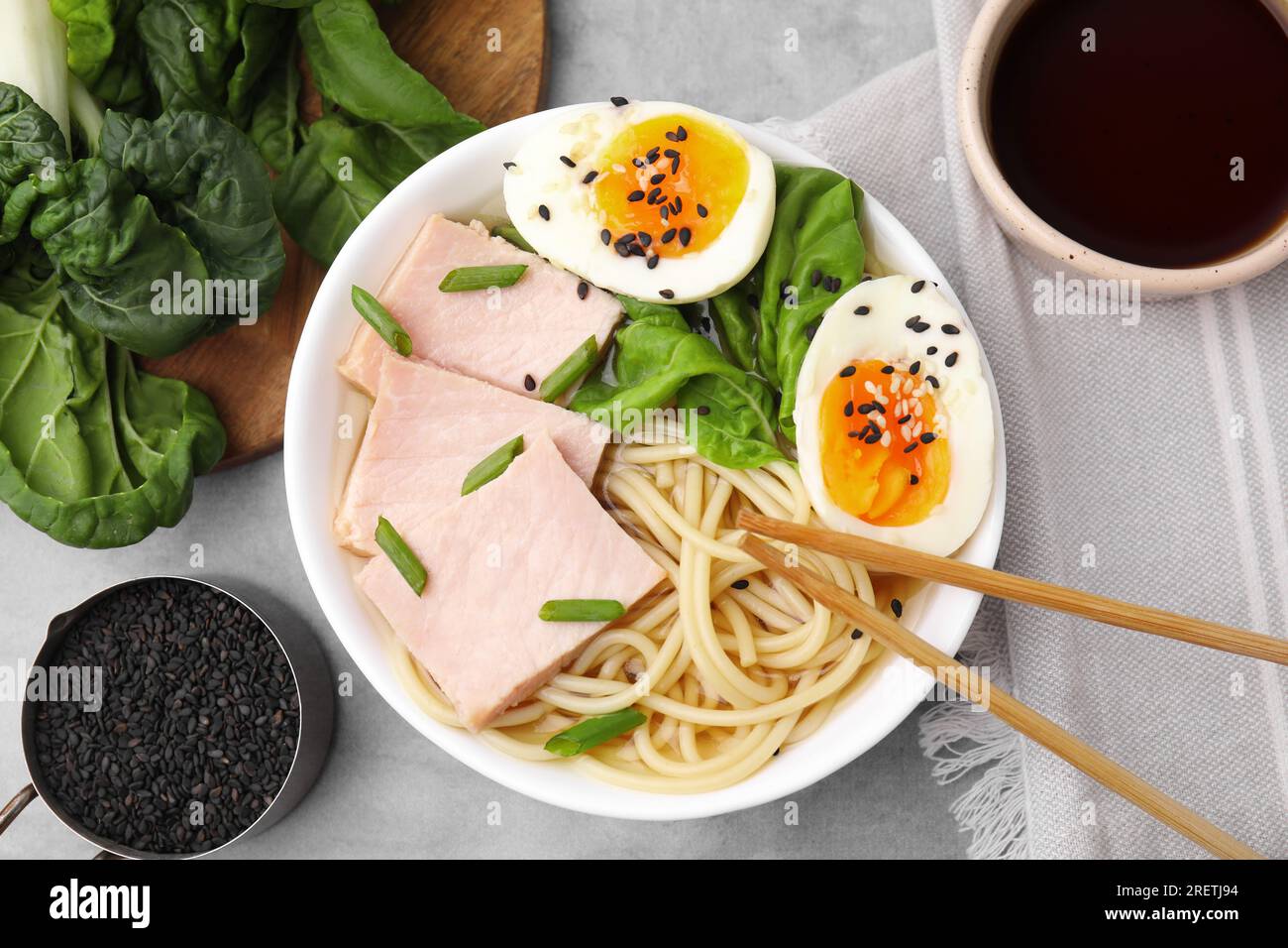 Delicious ramen with meat served on grey table, flat lay. Noodle soup ...