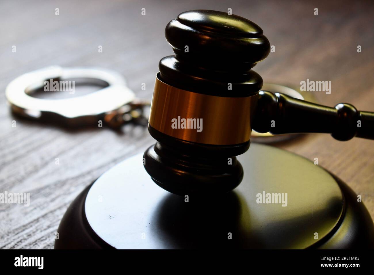 Judge’s gavel and block with handcuffs on a dark wooden table Stock ...