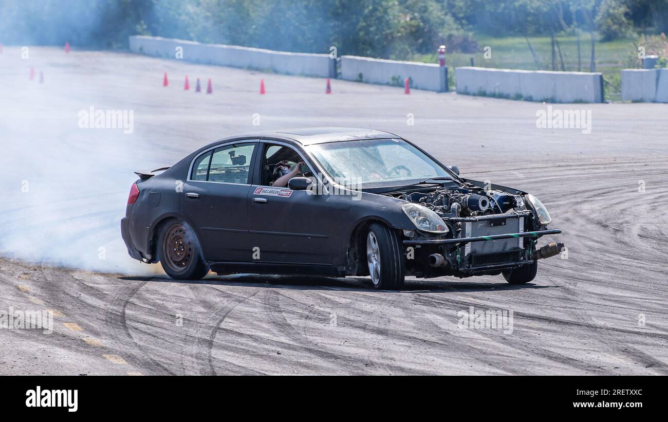 Car drifting auto racing event action with smoking tires - burning ...