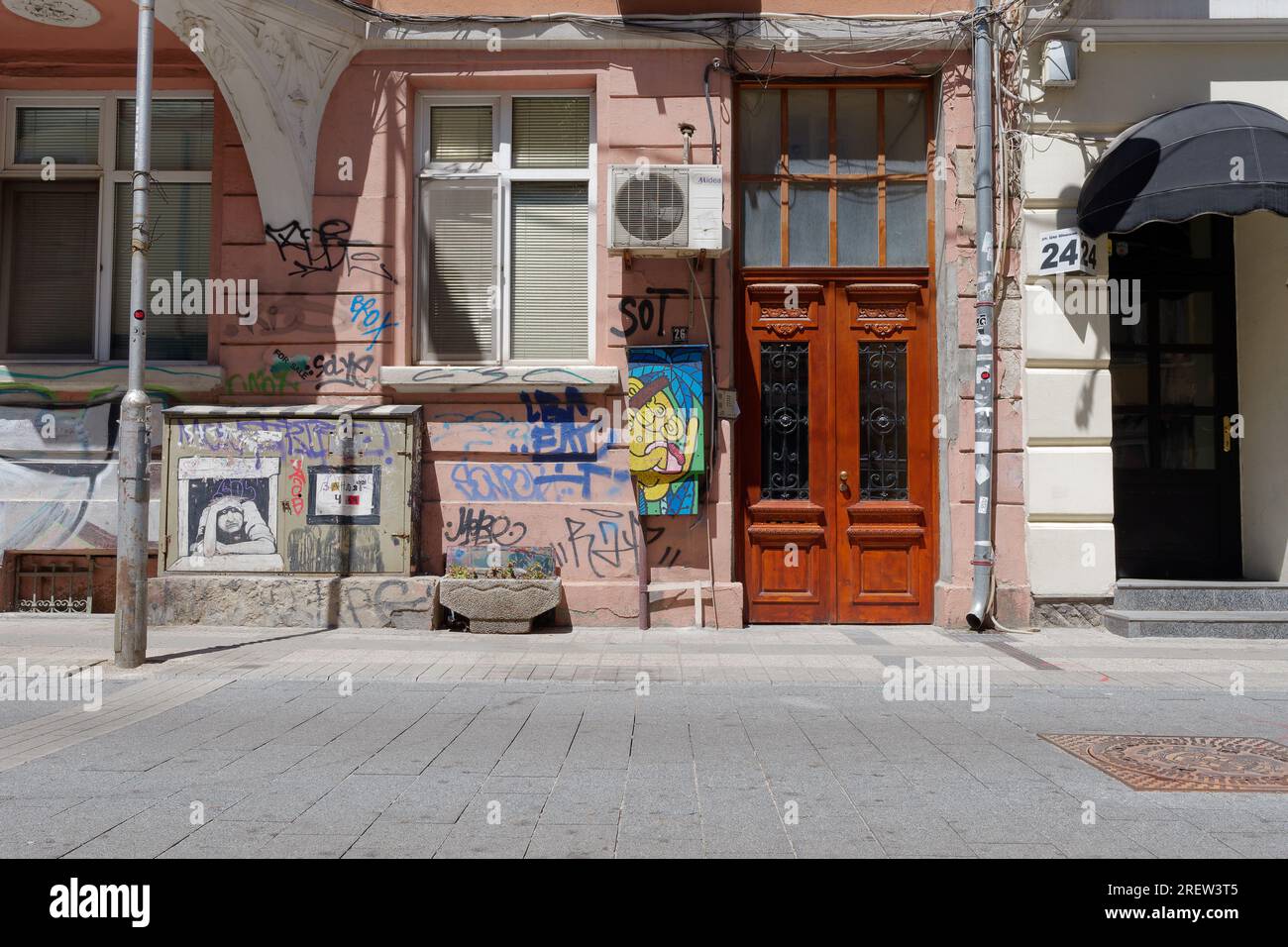 Peach building with dark brown door with an illustration of a sad ...
