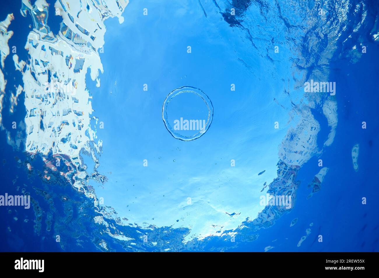 From below underwater of air ring flowing on surface of transparent ...