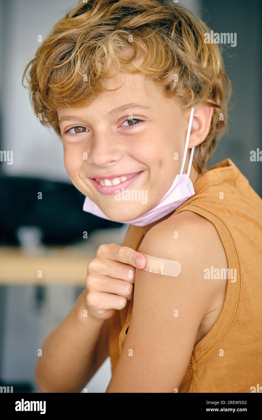 Side view of content child with brown hair and sterile mask looking at ...