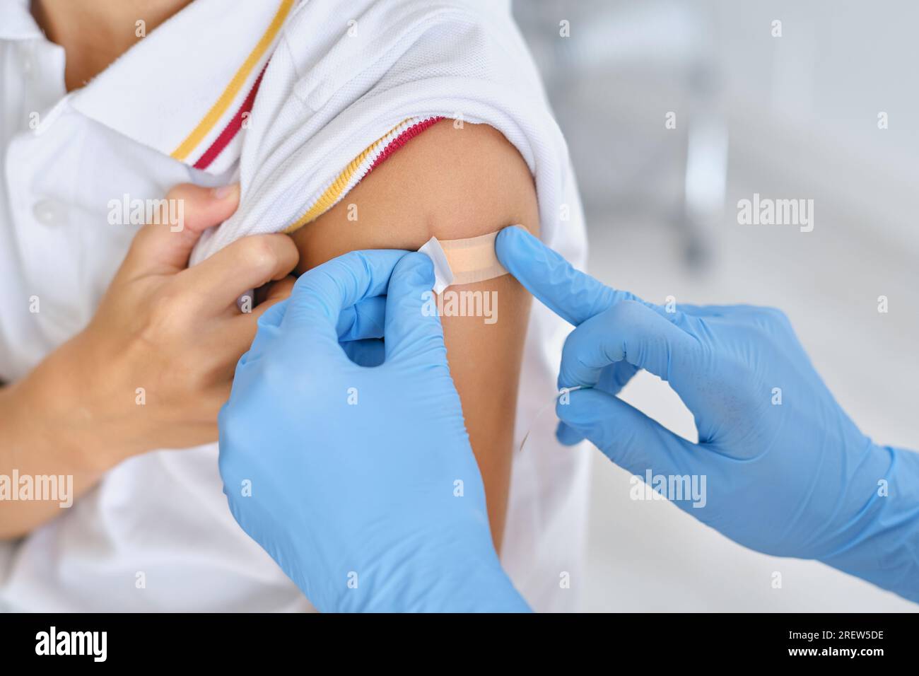 Crop unrecognizable nurse in disposable gloves applying medical patch ...