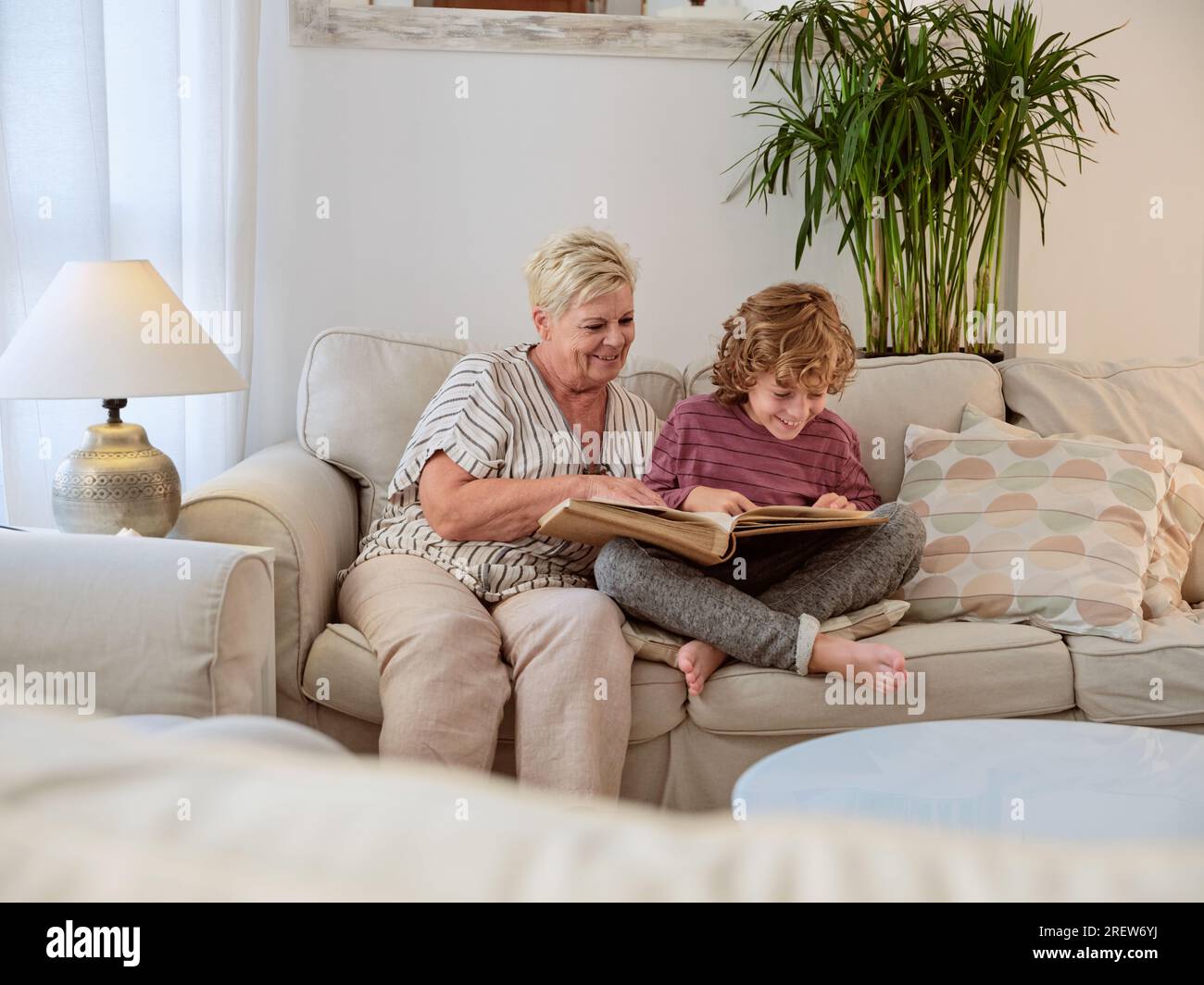 Positive elderly woman sitting near grandson and showing interesting ...