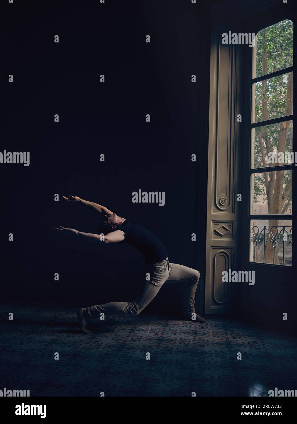 Side view of guy bending back and raising arms against door with glass ...