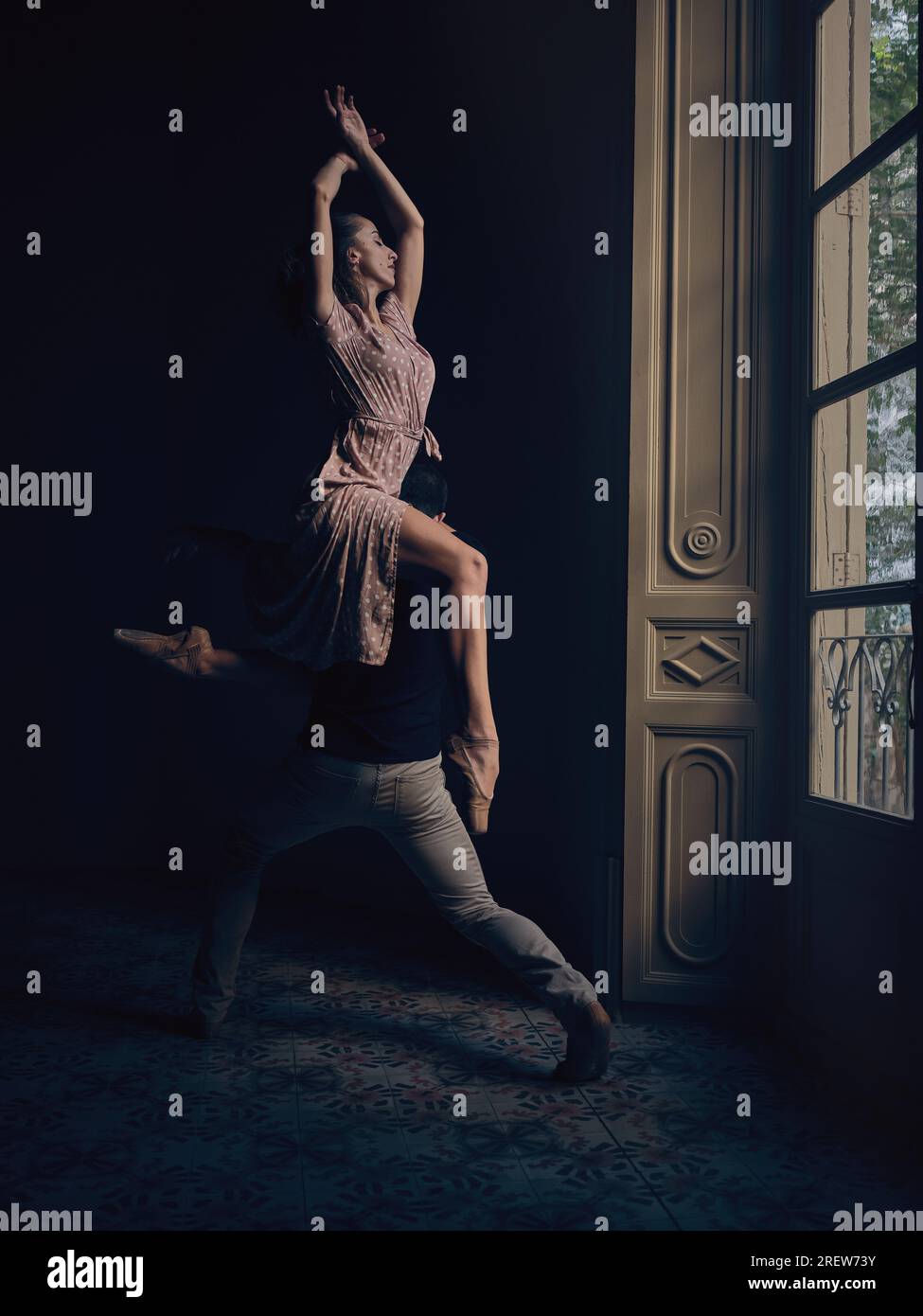 Full body side view of faceless male ballet dancer carrying on shoulder ...