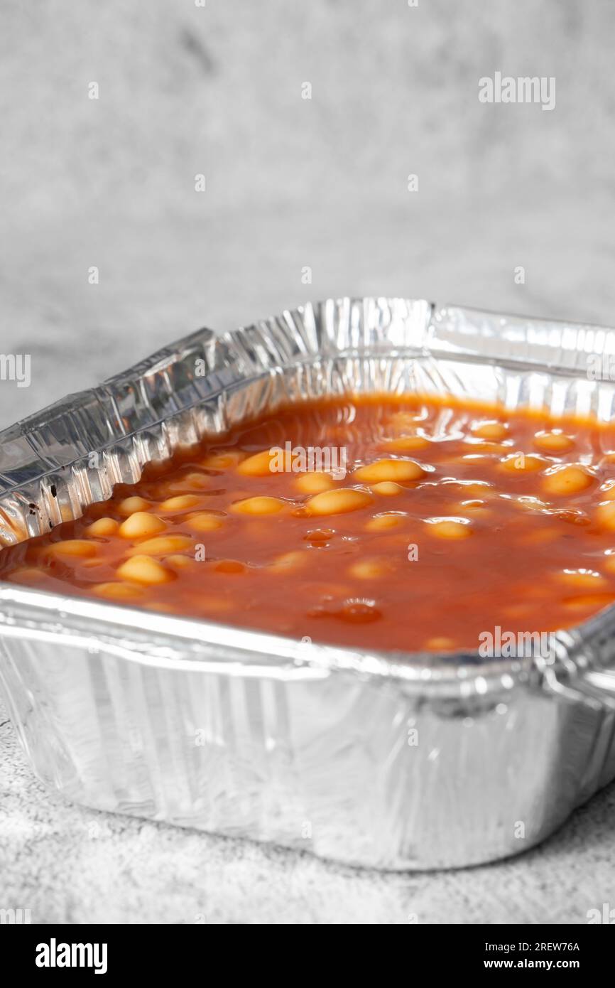 Baked beans, in a tomato sauce, in a takeaway foil tray carton ...