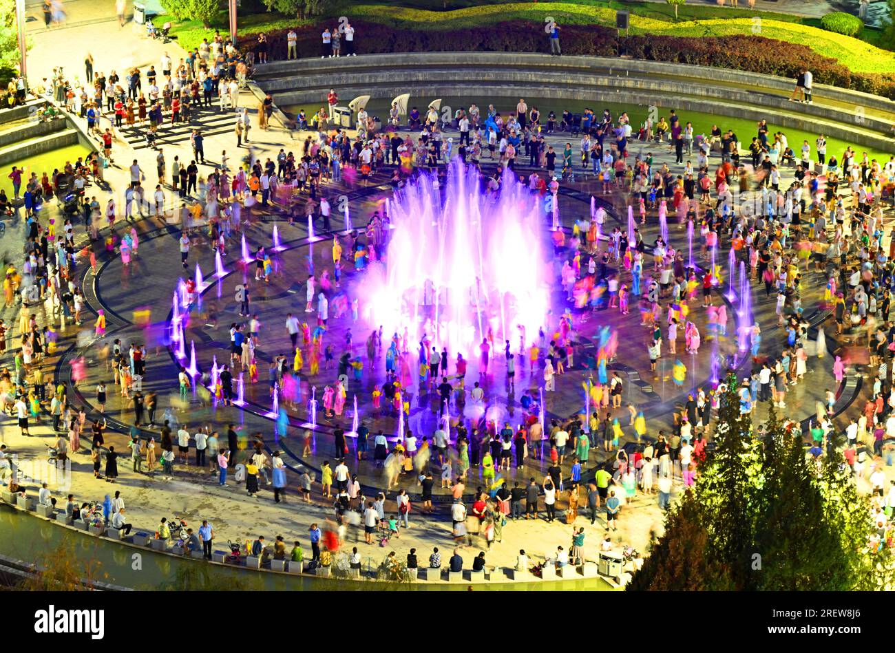 KORLA, CHINA - JULY 28, 2023 - People cool off in front of a music ...