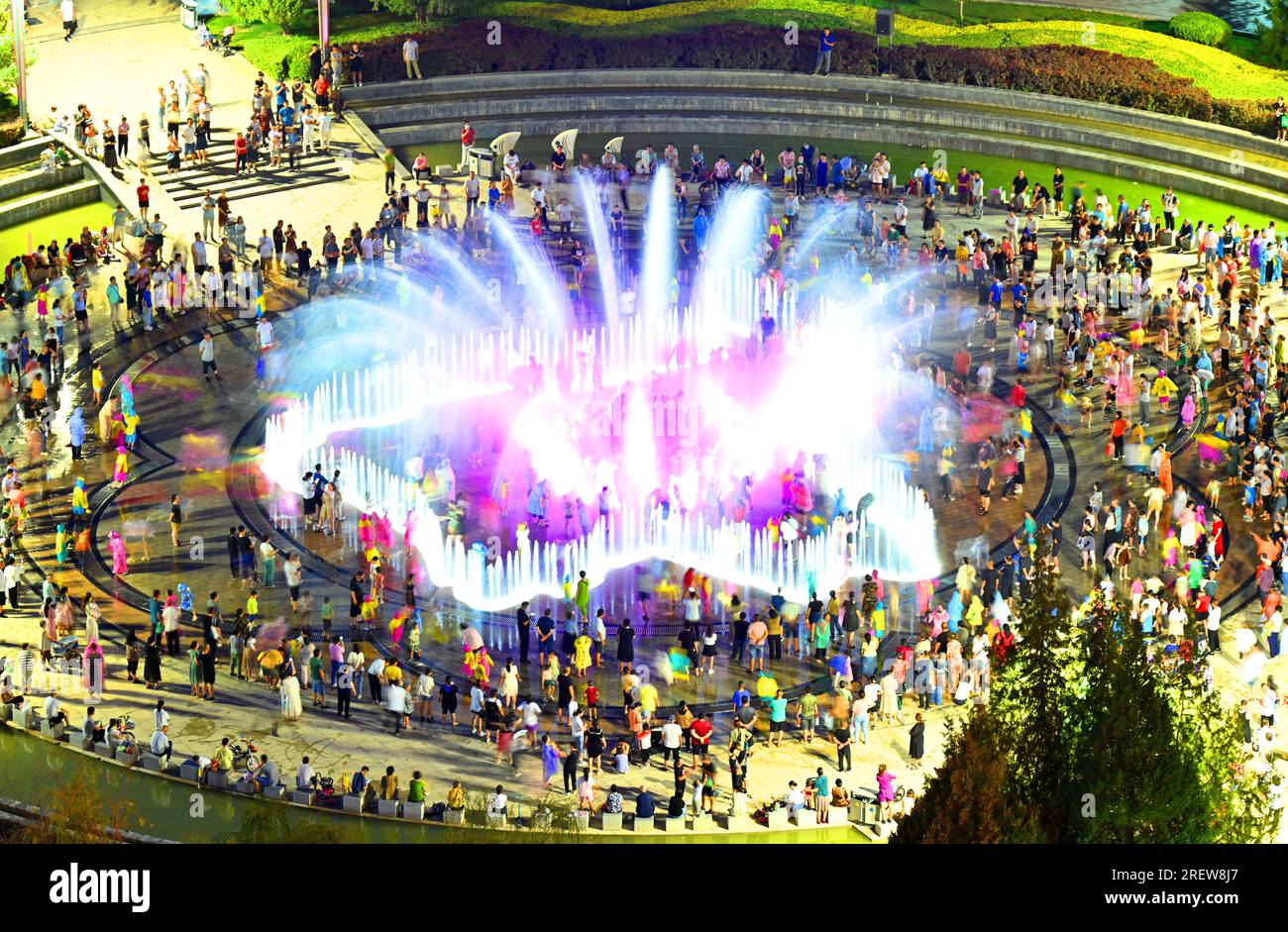 KORLA, CHINA - JULY 28, 2023 - People cool off in front of a music ...