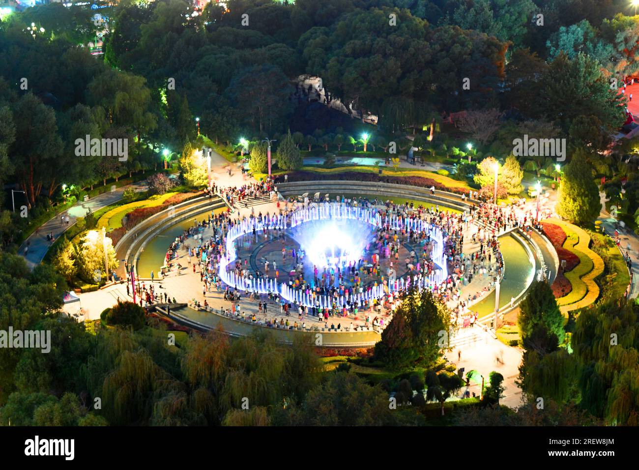 KORLA, CHINA - JULY 28, 2023 - People cool off in front of a music ...