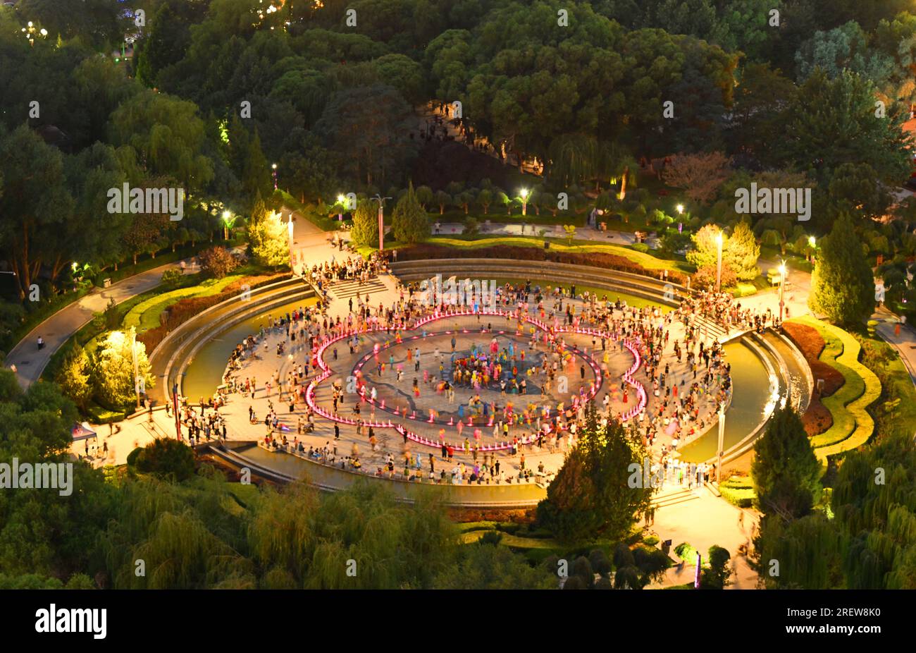 KORLA, CHINA - JULY 28, 2023 - People cool off in front of a music ...