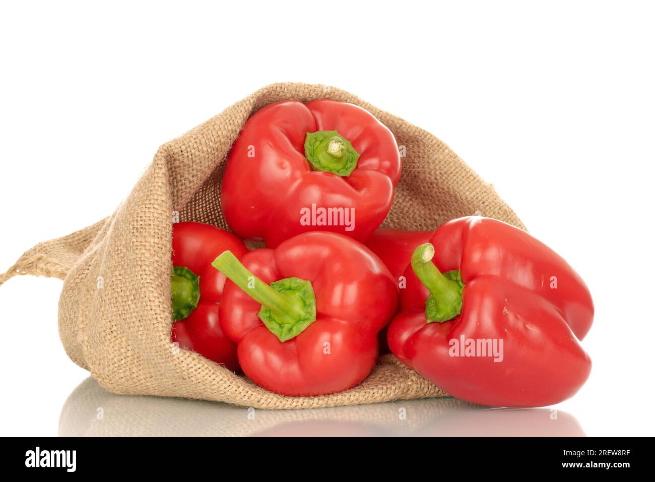 Several red bell peppers in a jute sack, macro, isolated on white ...