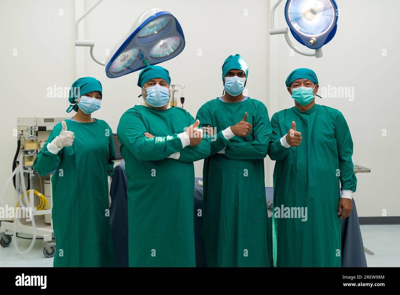 A team of four surgeons dressed in scrubs, standing amid the sterile ...