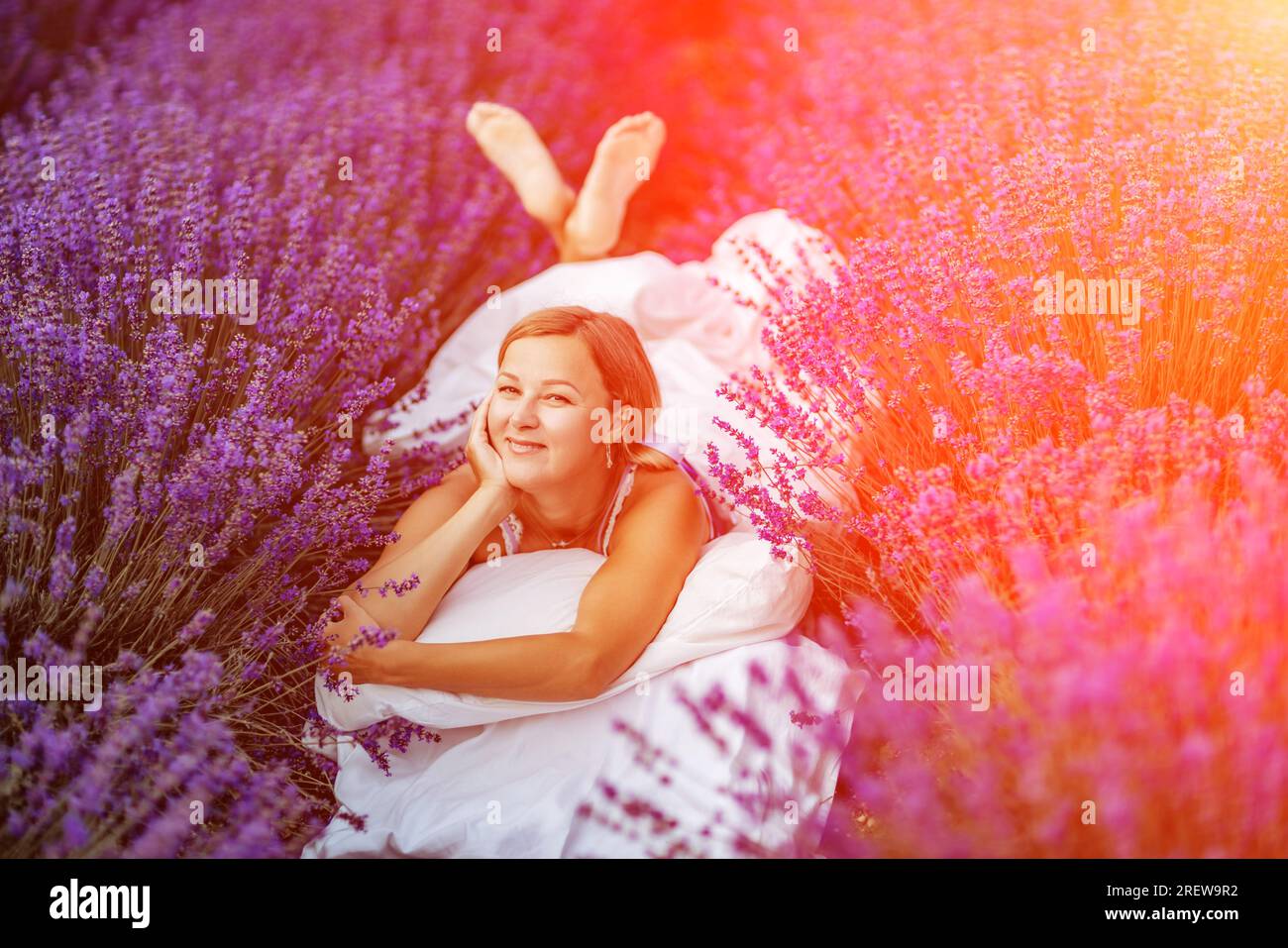 Woman lavender field. A middle-aged woman lies in a lavender field and ...