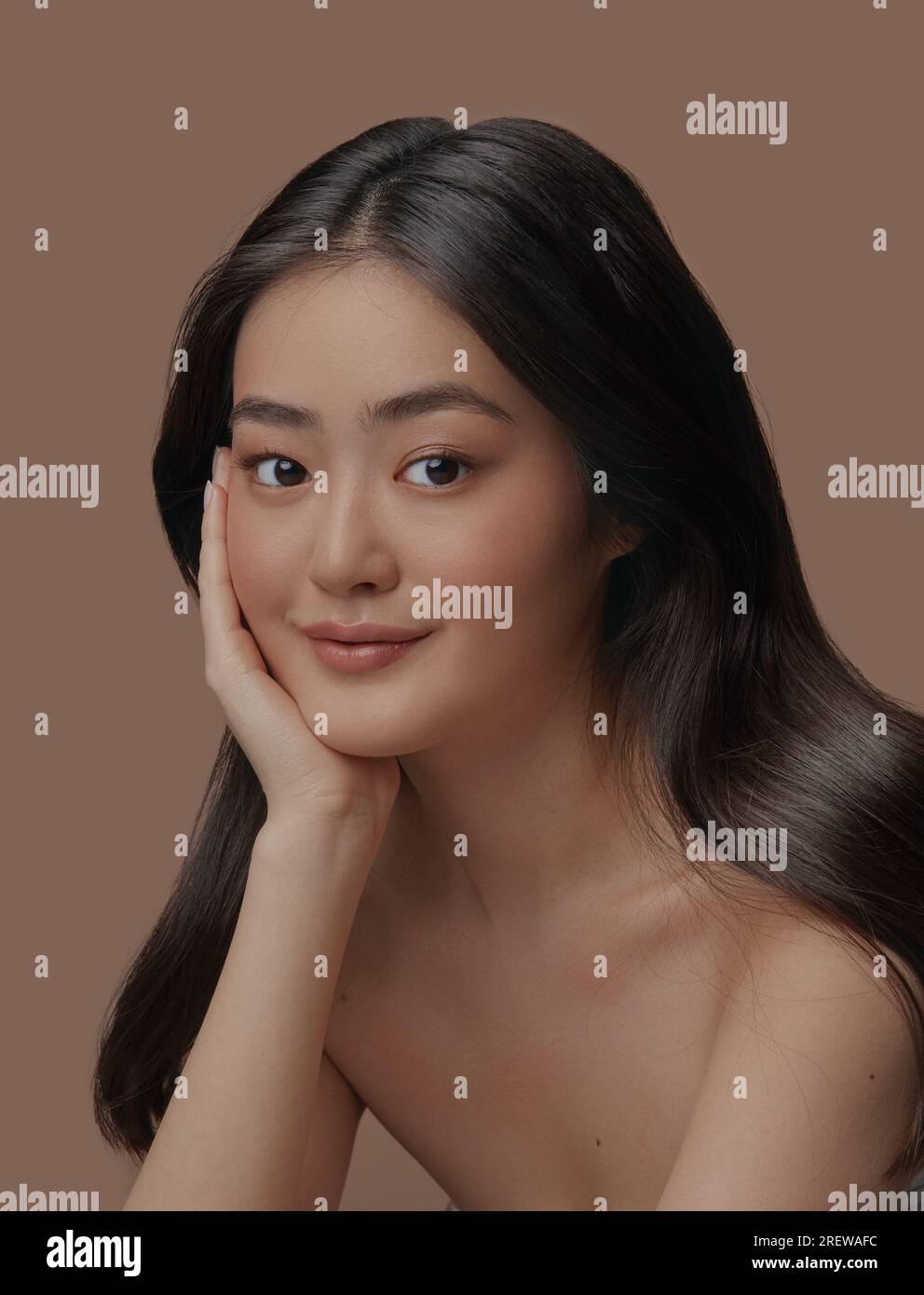 Charming young asian woman with a healthy clean skin leans hand at the ...