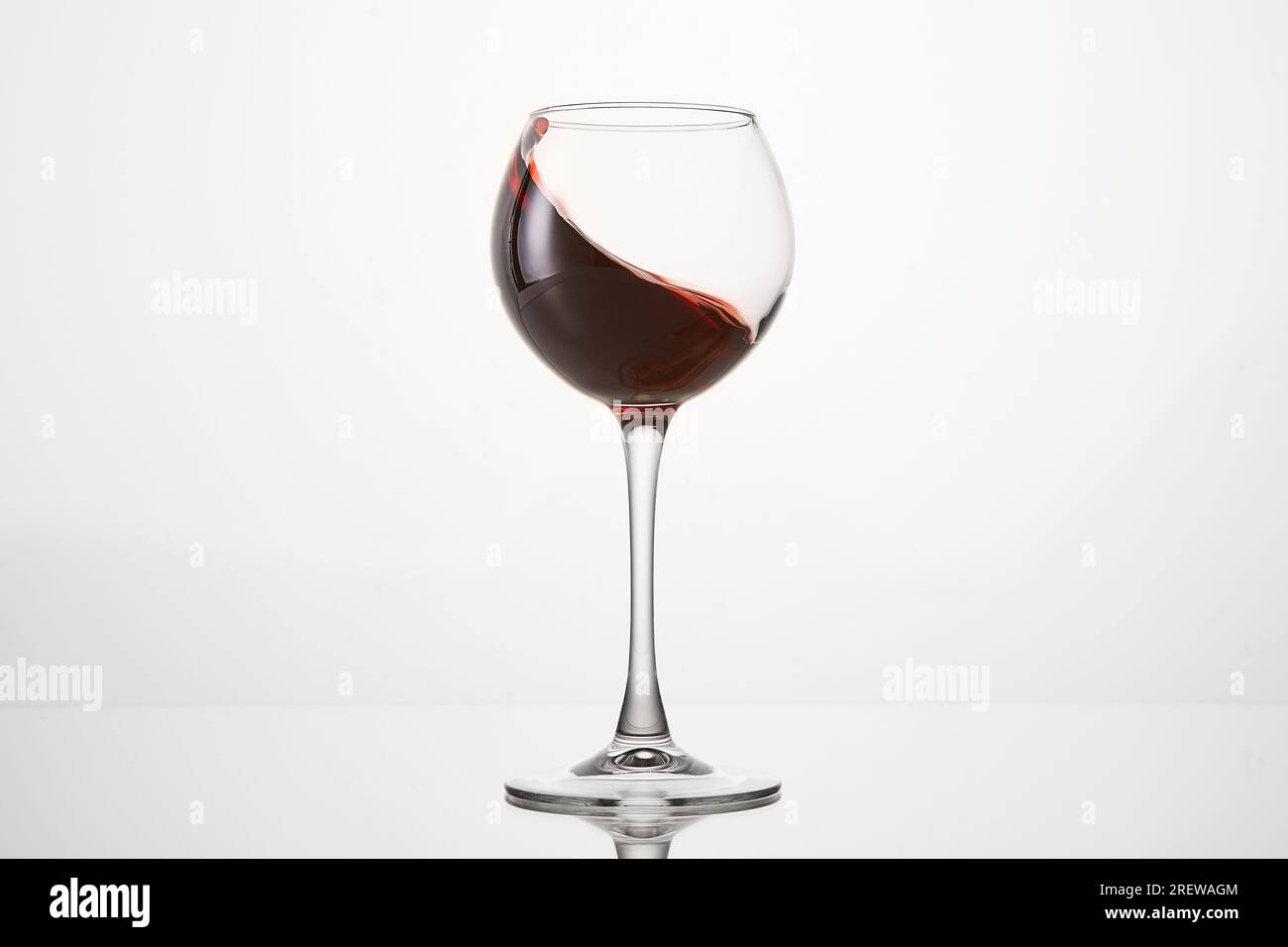 Red wine diagonal wave, curl is in stemmed glass Stock Photo - Alamy