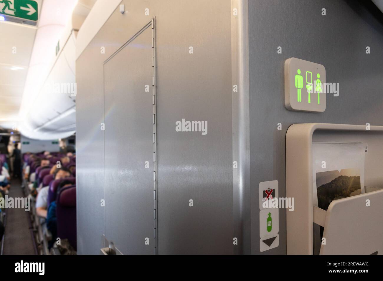 Lavatory signage on airplan cabin wall lighted green suggests it is not ...