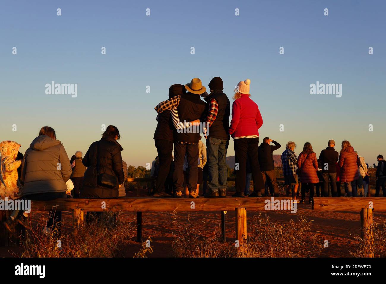Rear View of People standing on a Bench for better Sunset Views of ...